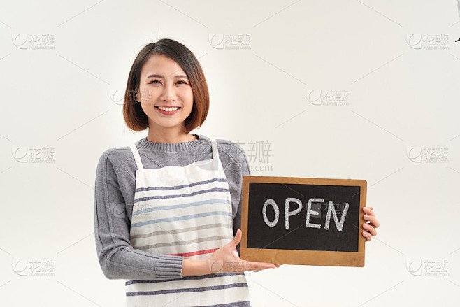 女性企业主举着白色的OPEN标志