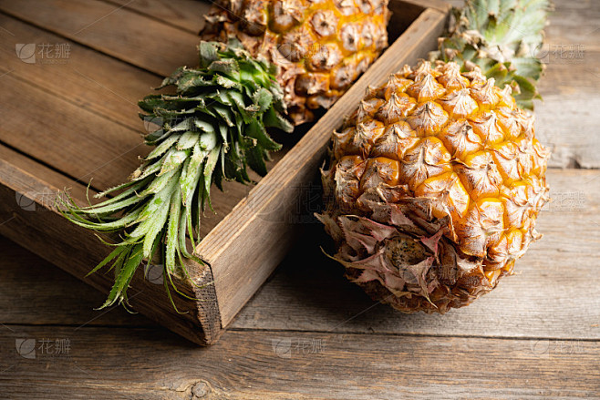 新鲜成熟的菠萝装在旧木箱里