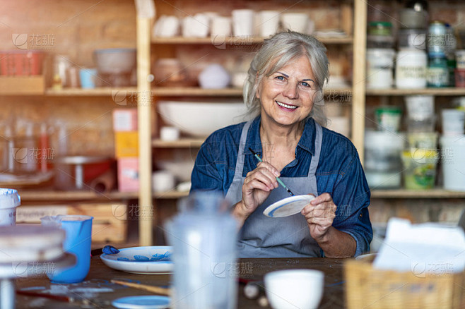 成熟的手工艺人在艺术工作室里画一个泥板