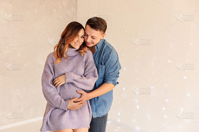 美丽怀孕的年轻家庭。孕妇和男人。幸福的夫妇，妻子和丈夫抱着肚子