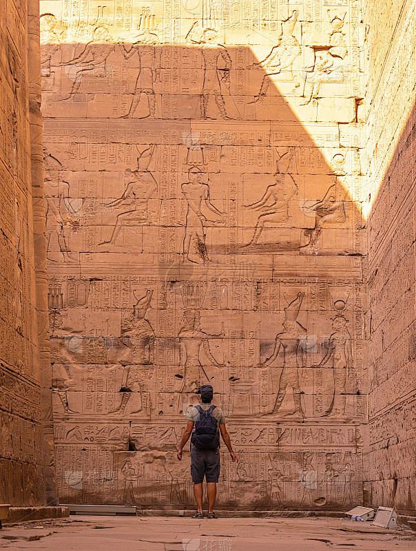 一个年轻的游客在埃及的Edfu城的Edfu神庙的象形走廊。尼罗河畔，古罗马建筑，供奉胡洛斯的庙宇