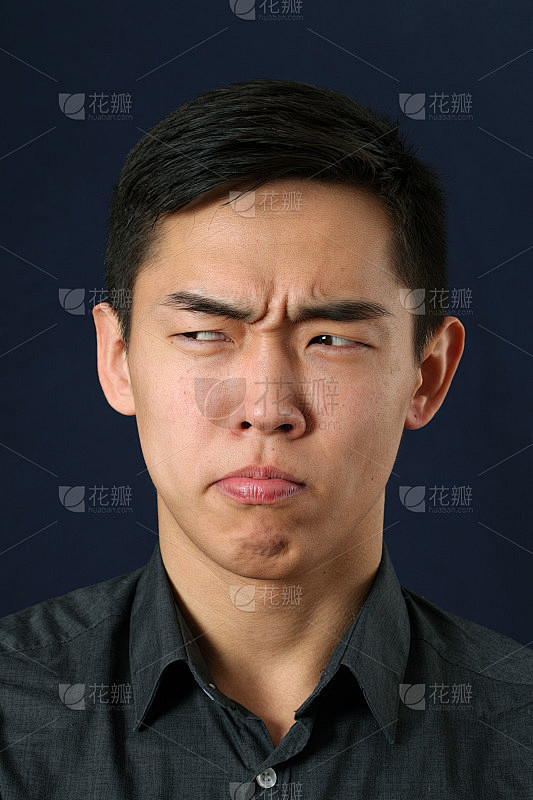 年轻的亚洲男人做着鬼脸，向旁边看 7081