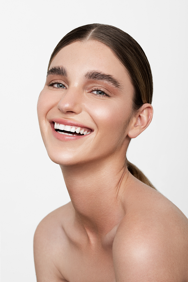 a woman with no shirt is smiling and looking at the camera