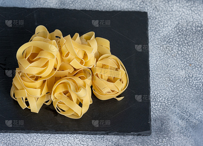 Rolled tagliatelle shape of italian pasta on black