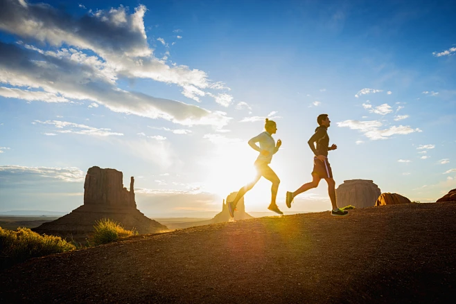 Caucasian couple running in Monument Valley, Utah, United States by ...