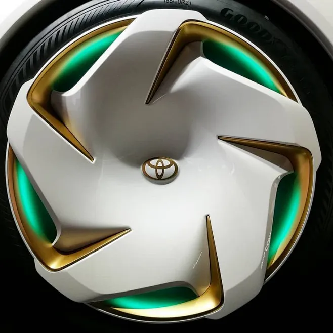This may contain: a white and green wheel cover with gold accents on it ...