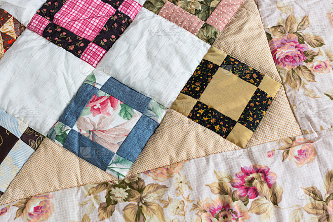 部分以复古花朵图案为背景的彩色拼布被子。色彩斑斓的小打小闹的毯子。爱好的概念