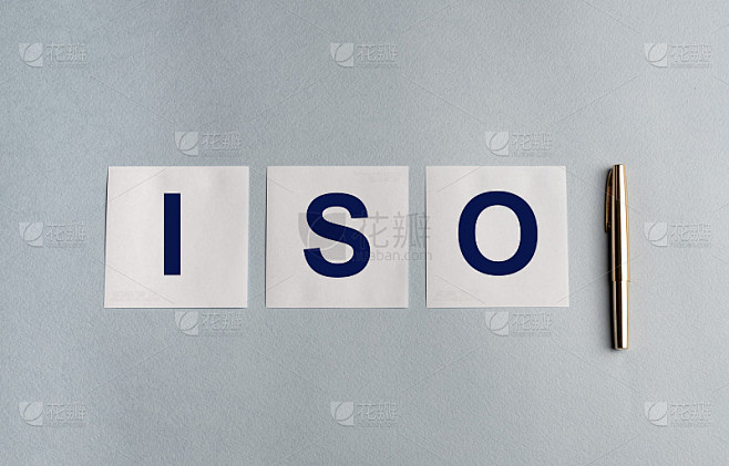 ISO字母在白色贴纸和笔在蓝灰色的背景