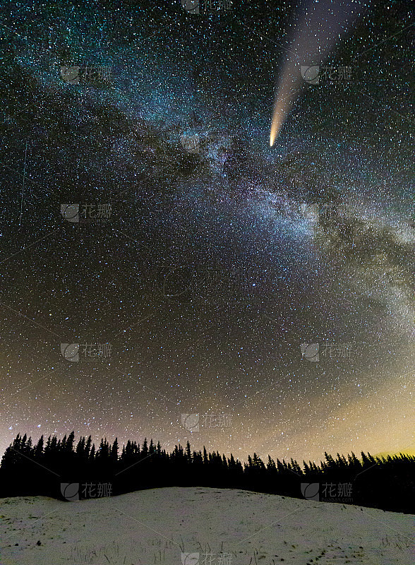 梦幻般的山地夜景，星空深蓝色的多云天空和C/2020 F3 (NEOWISE)彗星的轻尾。