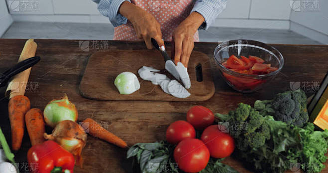 partial view of housewife cutting fresh onion near