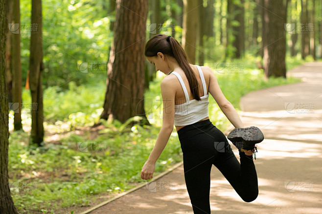 Girl warming up in the park before jogging, doing