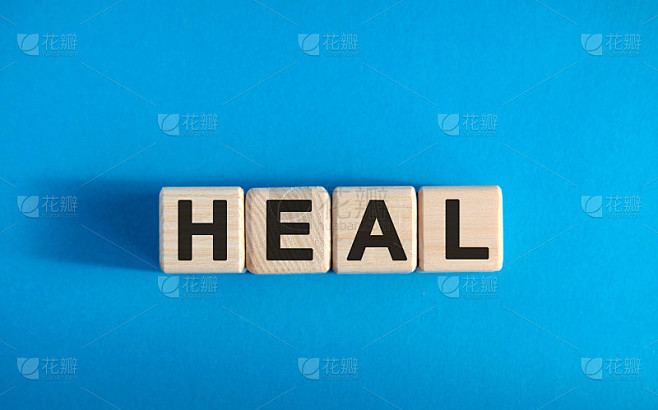HEAL -木制方块上的文本，医学概念，蓝色背景