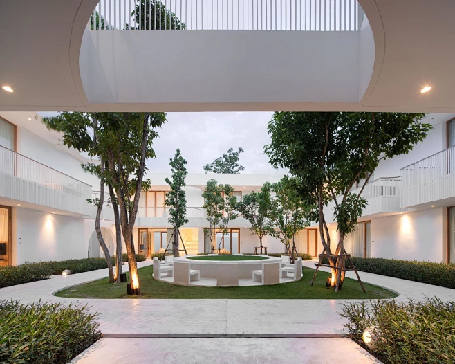 A modern hotel courtyard with outdoor chairs arranged in a circle.-花瓣网