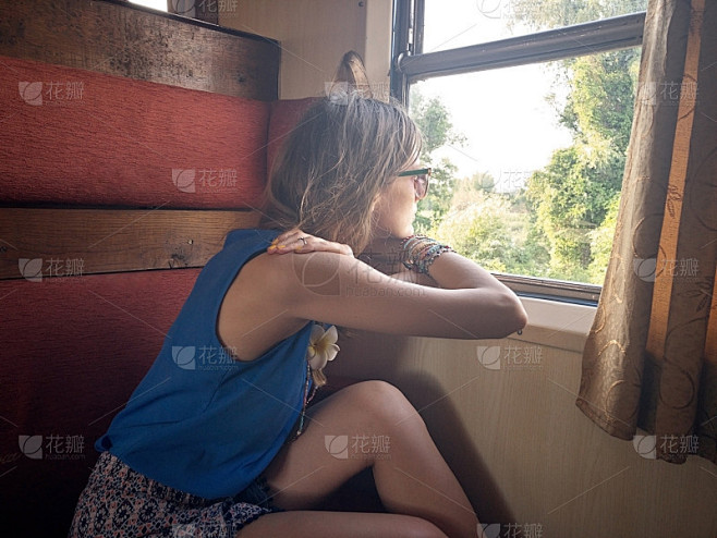 坐在老式火车车厢里的女游客。