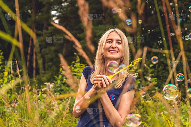 Young beautiful blonde woman blowing soap bubbles