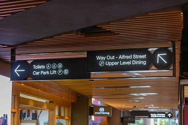 Directional sign suspended from timber batten ceiling-花瓣网