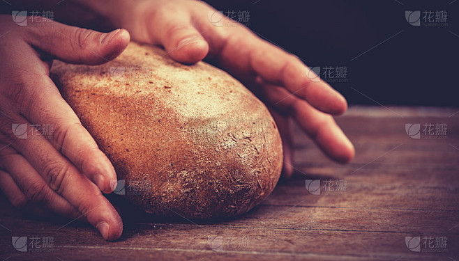 面包师的手拿着面包。