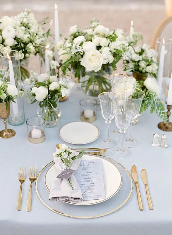 The delicate place settings included glass chargers, matte gold cutlery ...