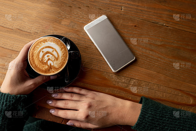 桌上放着一杯咖啡和智能手机。