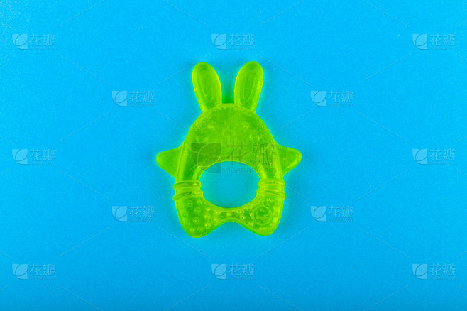 儿童牙齿玩具。以兔子的形式出现。绿色的颜色。刷你的牙齿。在蓝色背景上。为题词的地方。给孩子刷牙。婴儿