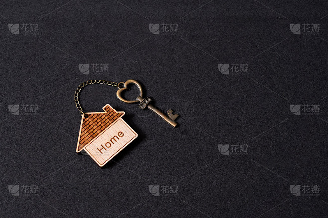 Home key with house keychain on black background,