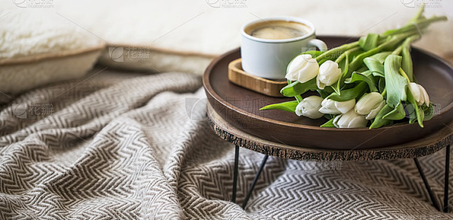 家庭室内装饰木桌，郁金香花束和咖啡杯，舒适的毯子，春天室内生活方式的装饰
