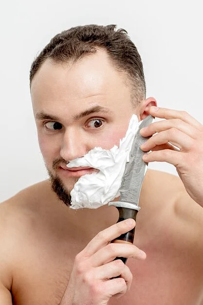Premium Photo | Young caucasian man shaving beard with knife-花瓣网