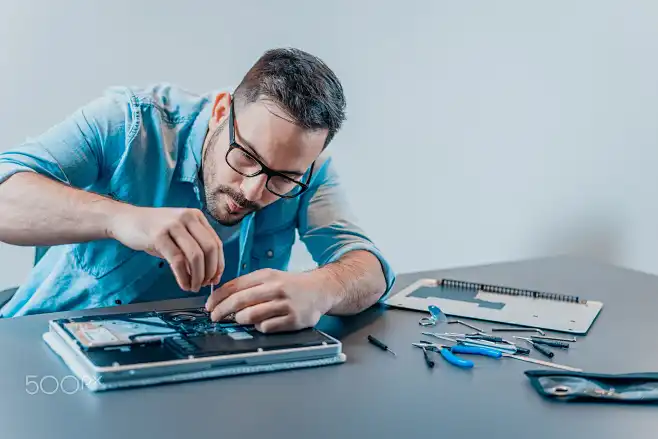 Handsome computer technician dismantling laptop by Branislav Nenin on ...