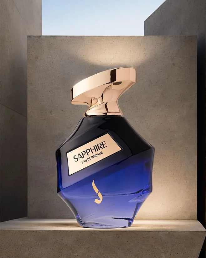 This may contain: a bottle of sapphire perfume sitting on top of a ...