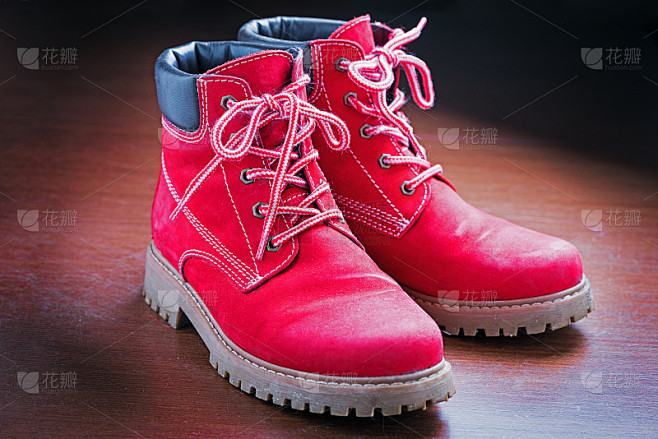 红靴子放在满是灰尘的木桌上。