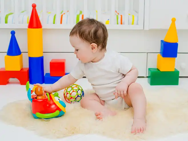 baby playing with educational toys lying by Yuliya Shangarey Shangarey ...