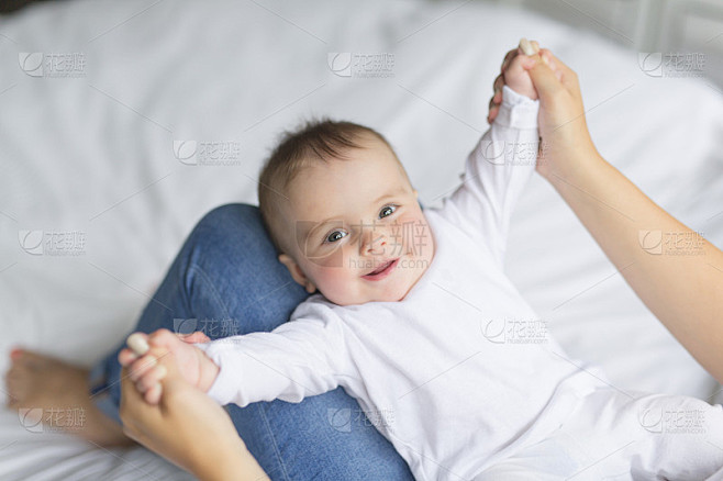 快乐幸福的家庭。妈妈和她的孩子在卧室里玩。近距离观察婴儿eow 0197
