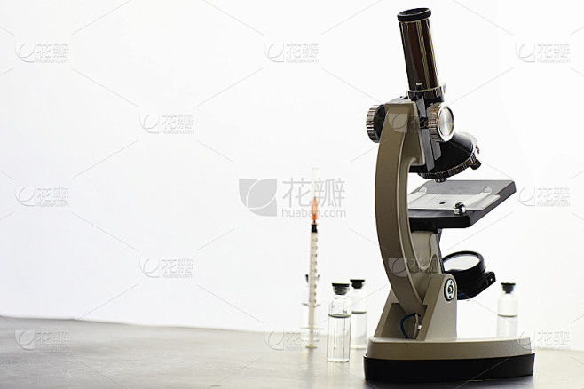 研究实验室。试管和显微镜放在桌子上，白色背景。
