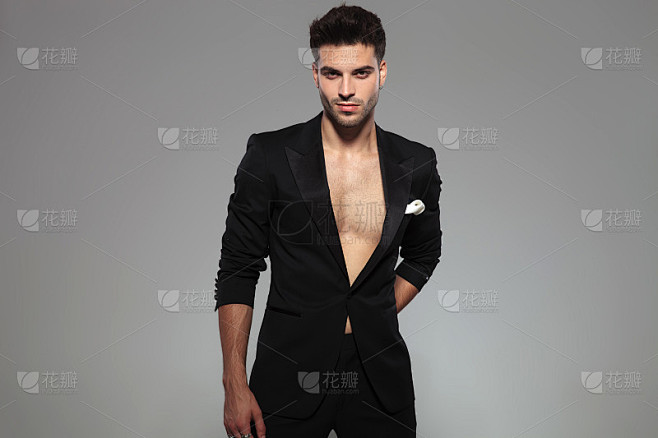 时尚男士站在身后，开心地藏着一件礼物