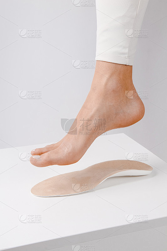 医疗鞋垫。孤立的矫形鞋垫在白色的背景。治疗和预防扁平足和足部疾病。足部护理。鞋垫剖面图层。腿挂在鞋垫