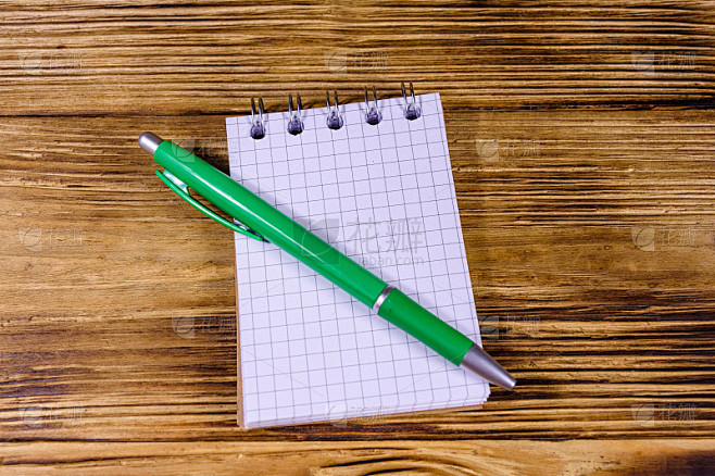 Opened small notepad and ball pen on a wooden tabl