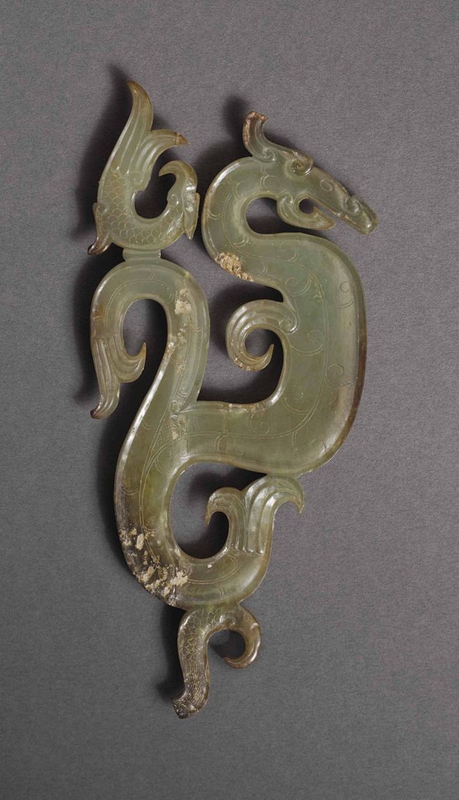 A RARE PALE GREYISH-GREEN JADE OPENWORK DRAGON-FORM PENDANT