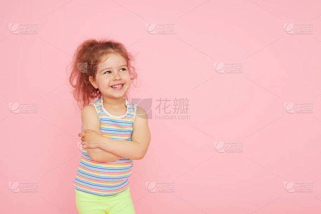 可爱的小女孩的画像，雪白的笑容，健康的牙齿，粉红的背景。看着摄像机笑着。儿童牙科诊所