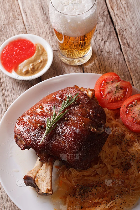 Eisbein:烤猪肉小腿和卷心菜特写和啤酒。垂直素材-花瓣网