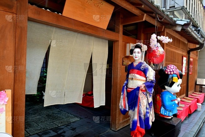 A Japanese woman in Maiko’s costume and hairstyle is standing in front ...