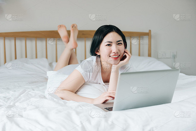 年轻的亚洲女孩在床上使用笔记本电脑 7942