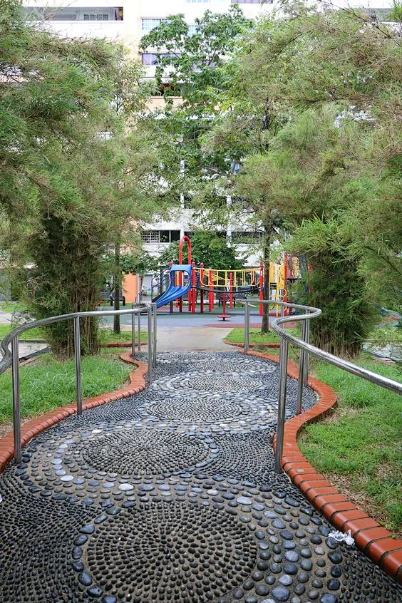 Beautiful pebble mosaic playground pathway. Kids play at the playground ...