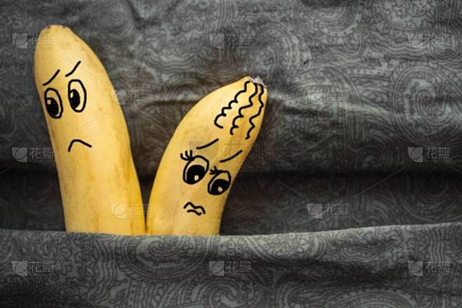 在床上，在黑暗的床单上，两只香蕉，一对夫妇。小费，怨恨，怨恨的伴侣。这幅画是作者创作的.