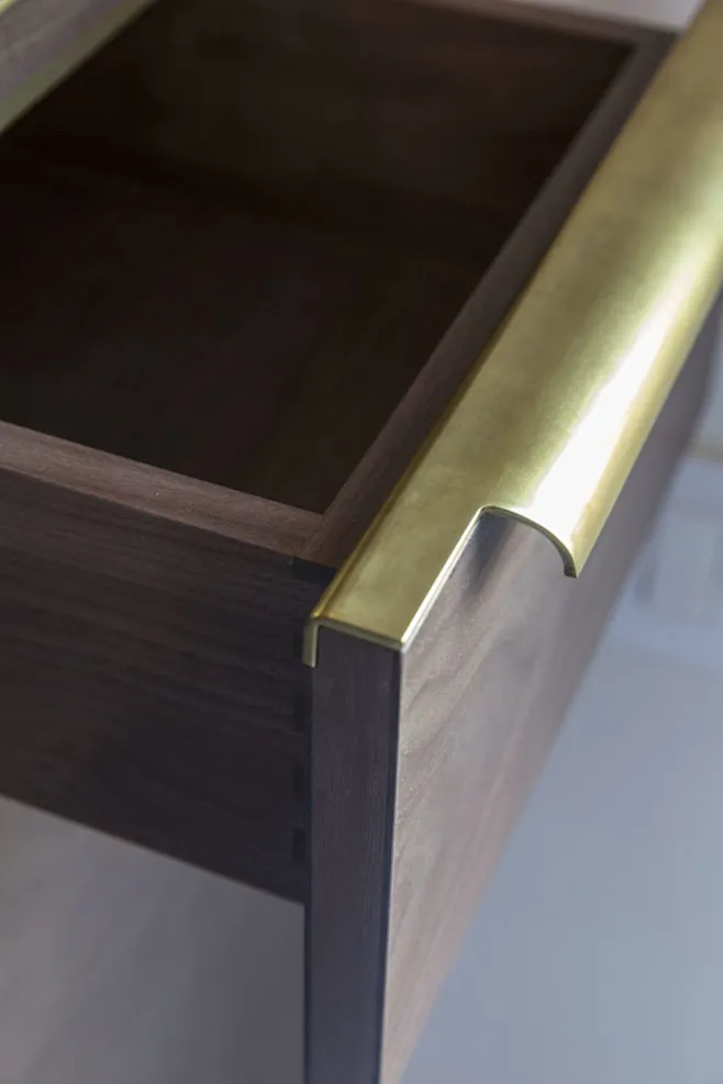 a close up view of a wooden table with brass trim on it's edge-花瓣网