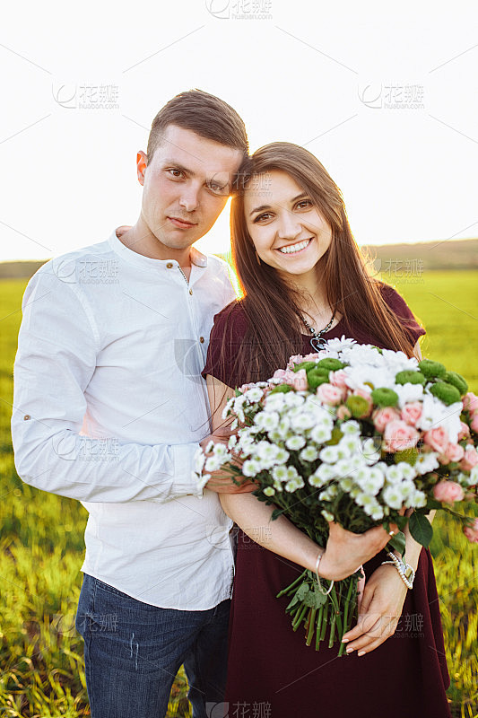 年轻幸福的情侣相爱，女孩捧着鲜花，幸福和享受彼此的陪伴，广告，和乌特萨瓦文字