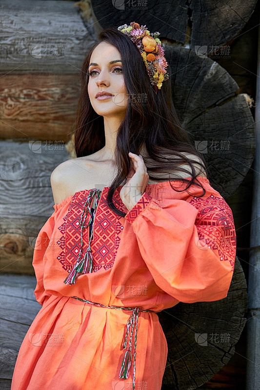 Beautiful Slavic woman in an orange ethnic dress a