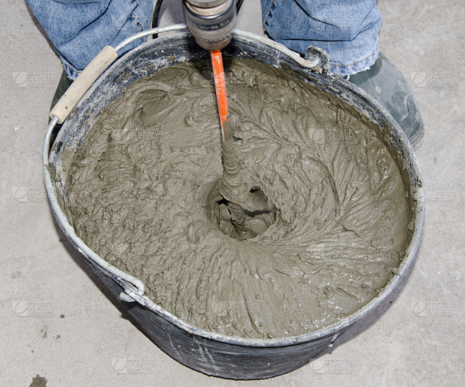 在铲斗内用电钻混合瓷砖粘合剂