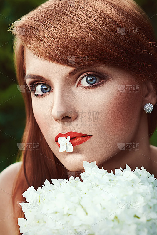 美丽的女孩嘴里叼着一朵花
