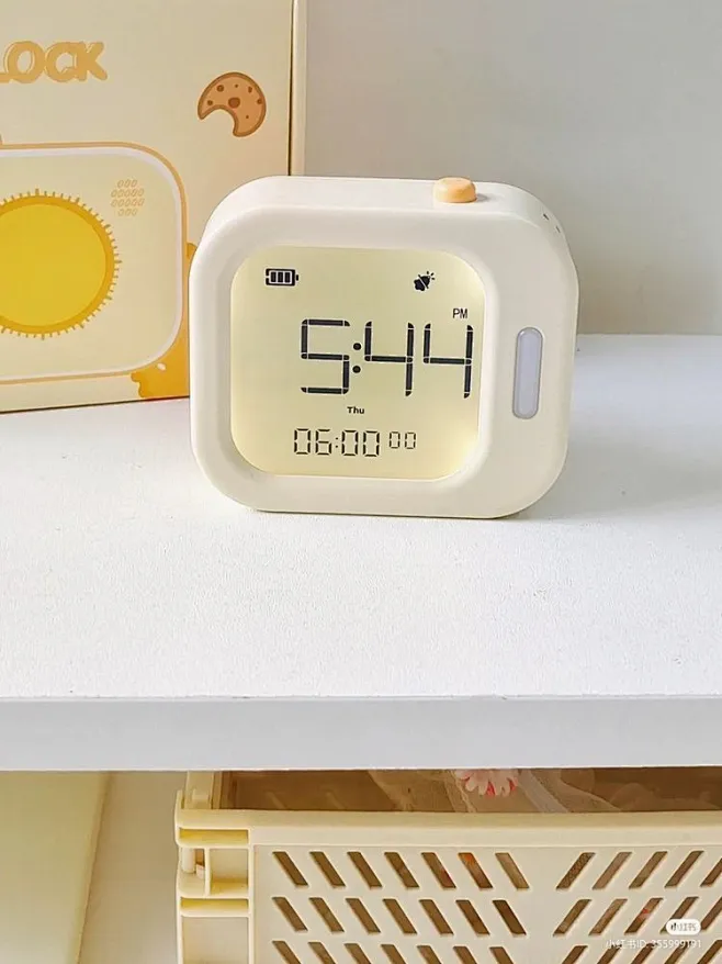 This may contain: an alarm clock sitting on top of a white shelf next ...