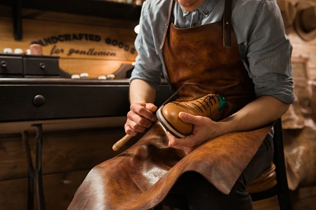 Bootmaker in workshop making shoes-花瓣网